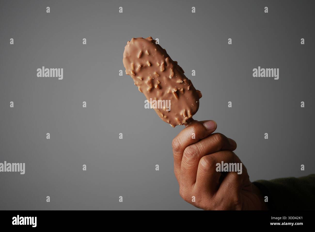 Person holds chocolate covered ice cream bar in hand Stock Photo - Alamy