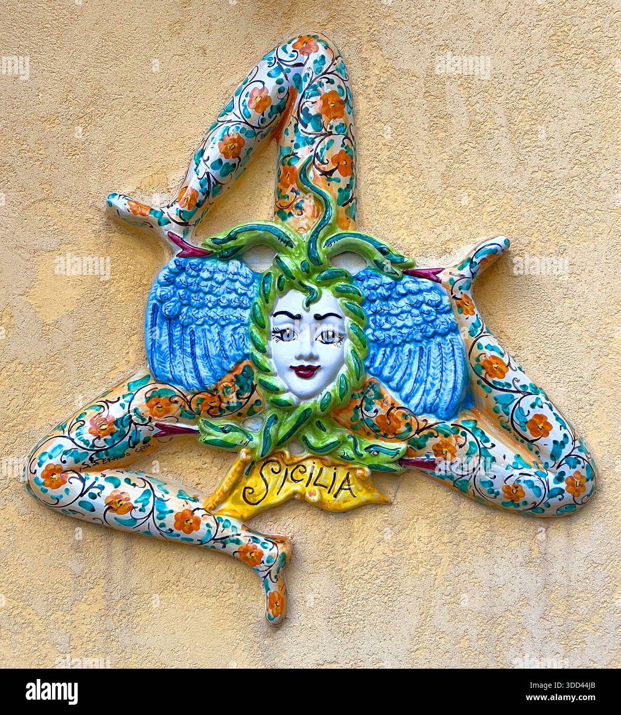 Ceramic trinacria symbol with medusa head and scrolling flora on a wall ...