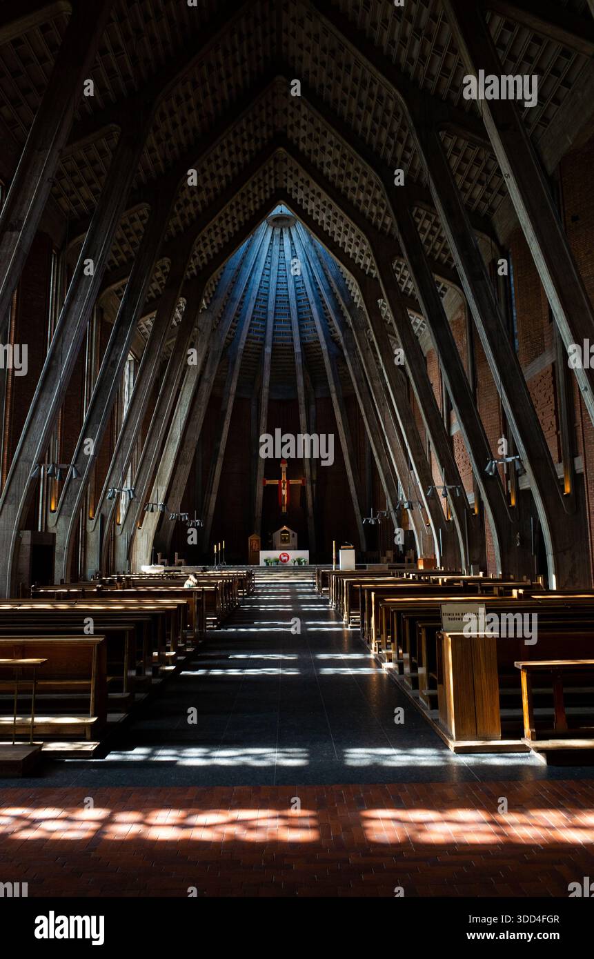 Symmetrical interior of a modern church with concrete arches, wooden ...