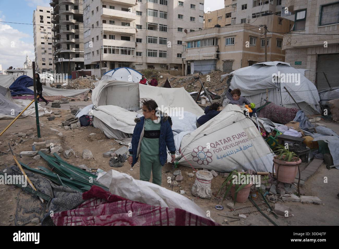 Palestinian members of the Al-Ajouri family stand by their tent that ...