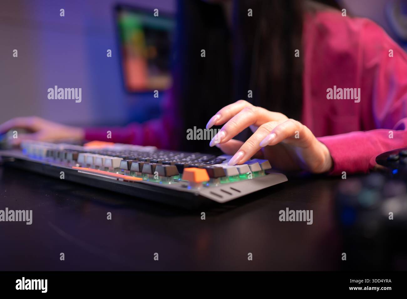Close-up of finger typing on a mechanical gaming keyboard in a colorful ...