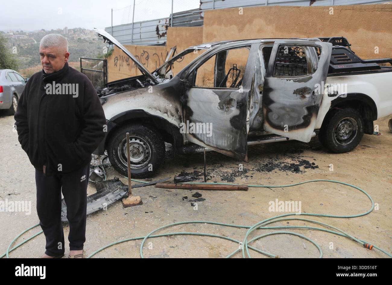 Palestinian Ayed Odeh seen standing beside his burned car after Israeli ...