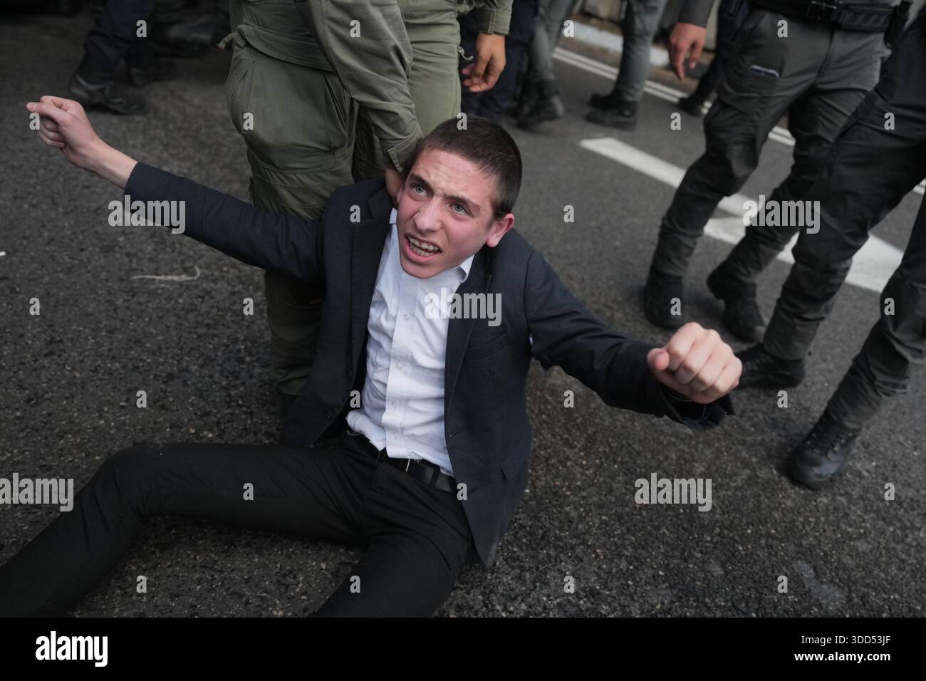 Ultra-Orthodox Jewish men block a highway during a protest against army ...
