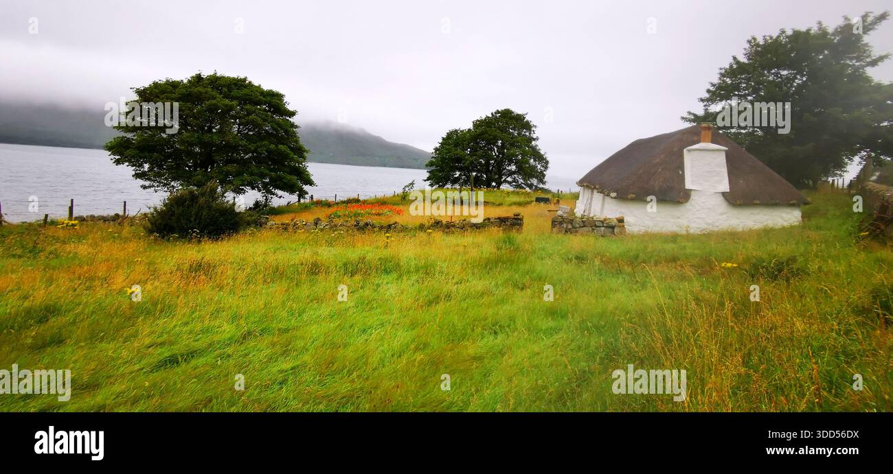 A traditional Scottish croft with a historic thatched roof set in the ...