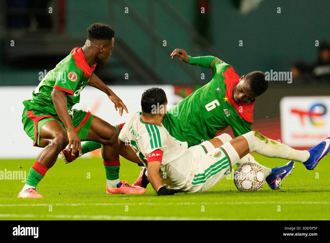 Algeria's Riyad Karim Mahrez, center, is tackled down by Burkina Faso's ...