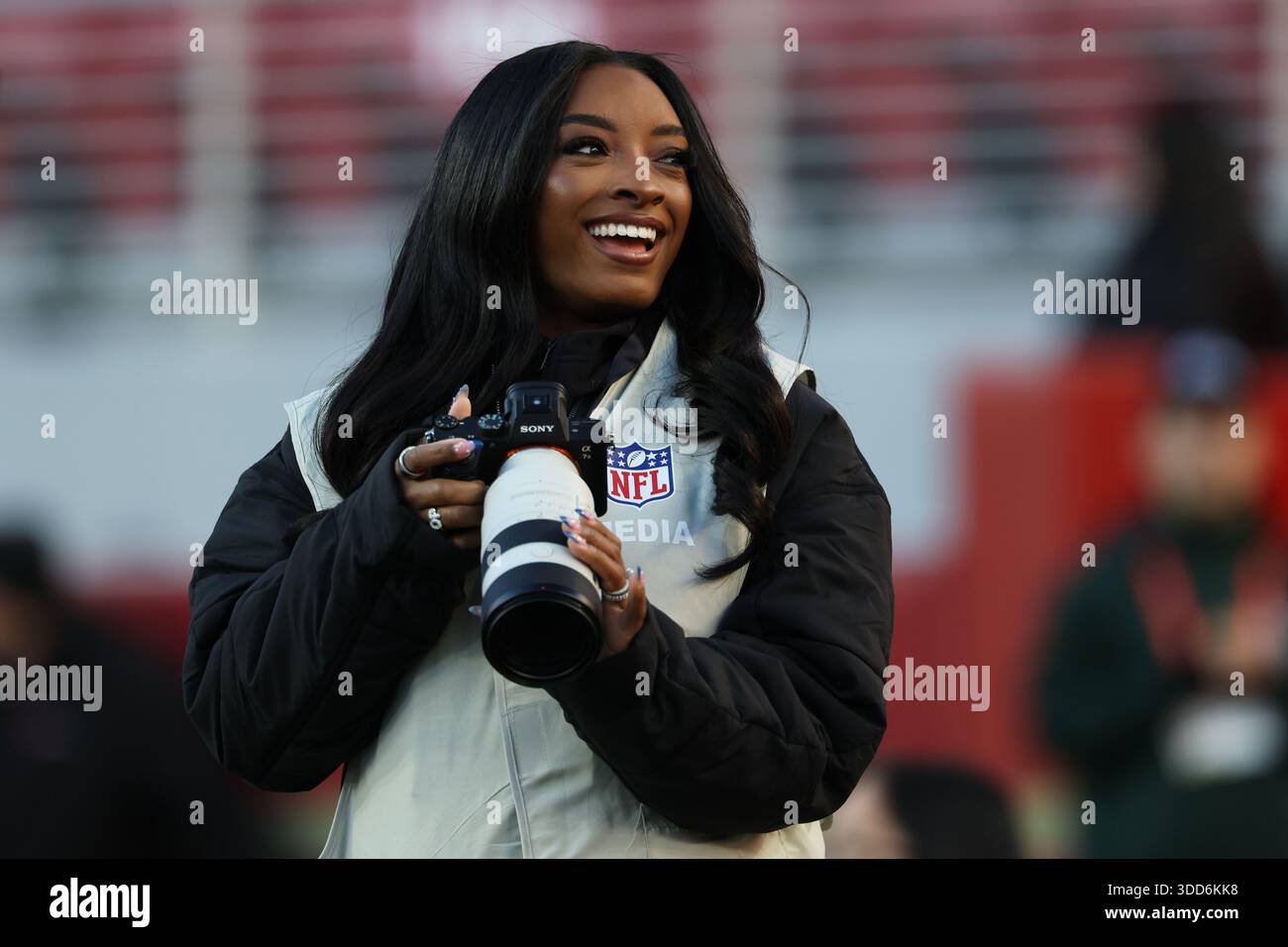 Simone Biles takes photos on the field before an NFL football game ...