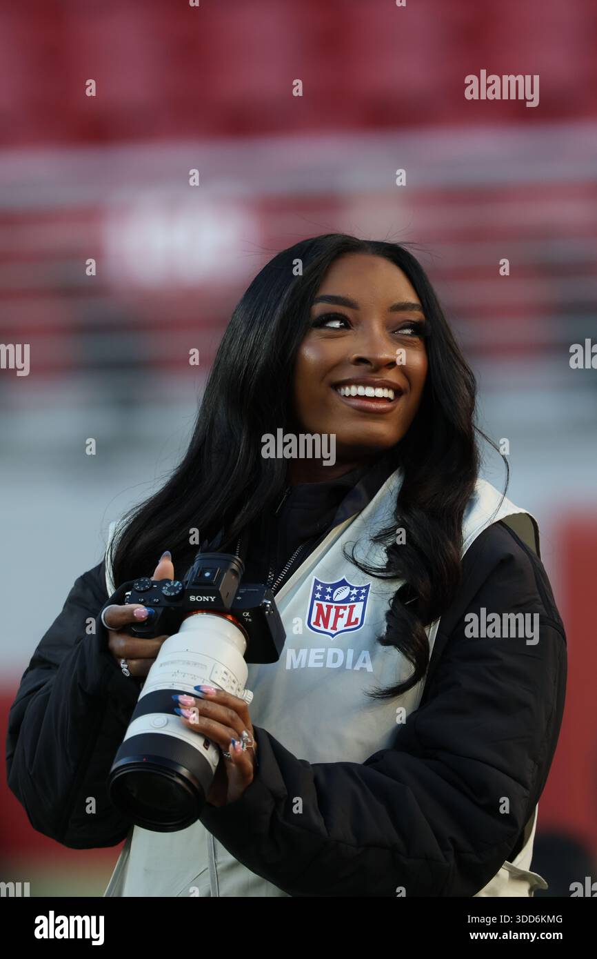 Simone Biles takes photos on the field before an NFL football game ...