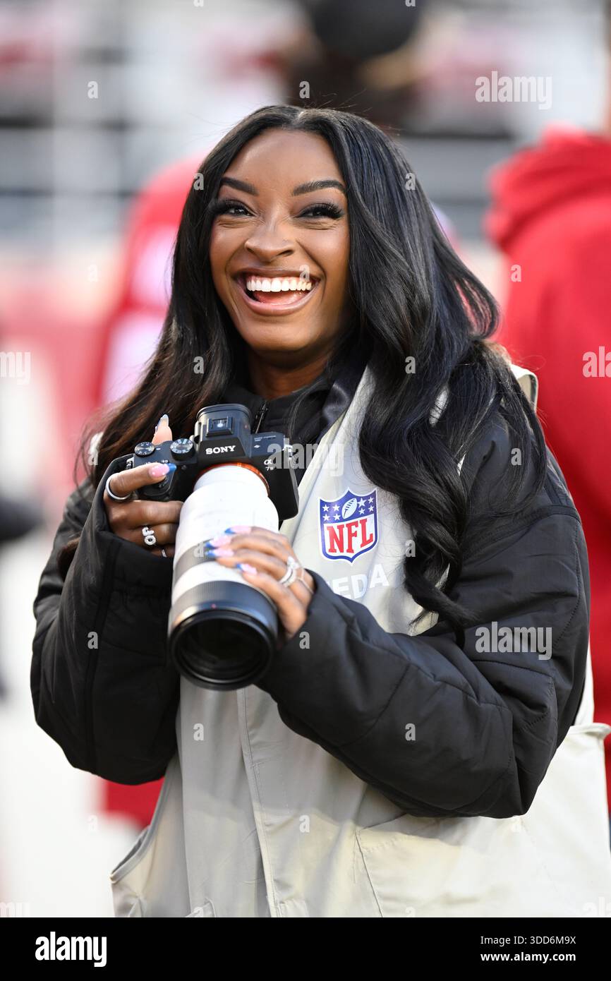 Simone Biles takes photos before an NFL football game between the San ...