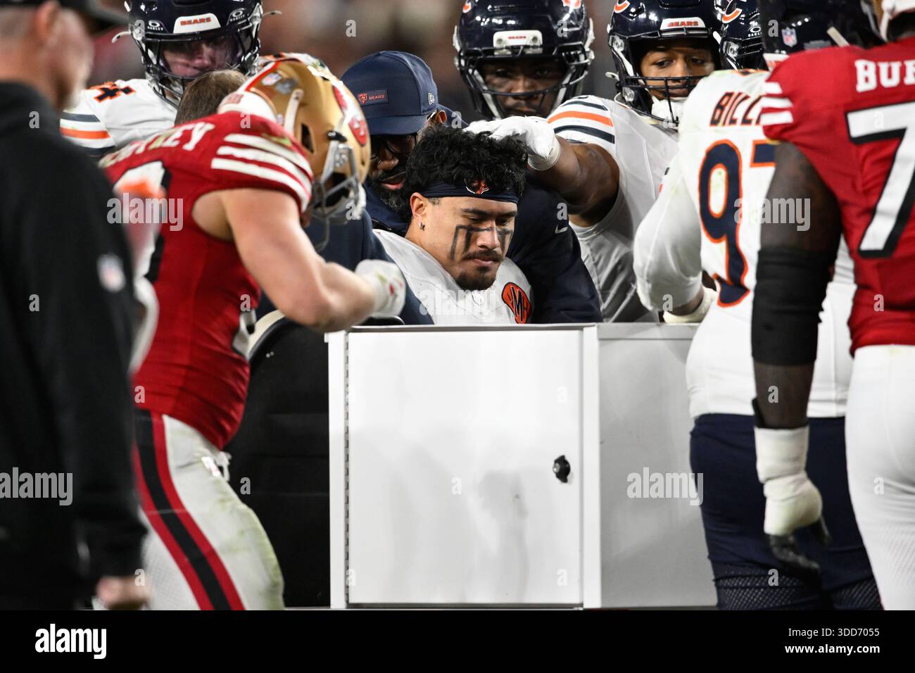 Chicago Bears linebacker Noah Sewell, middle, is helped off the field ...