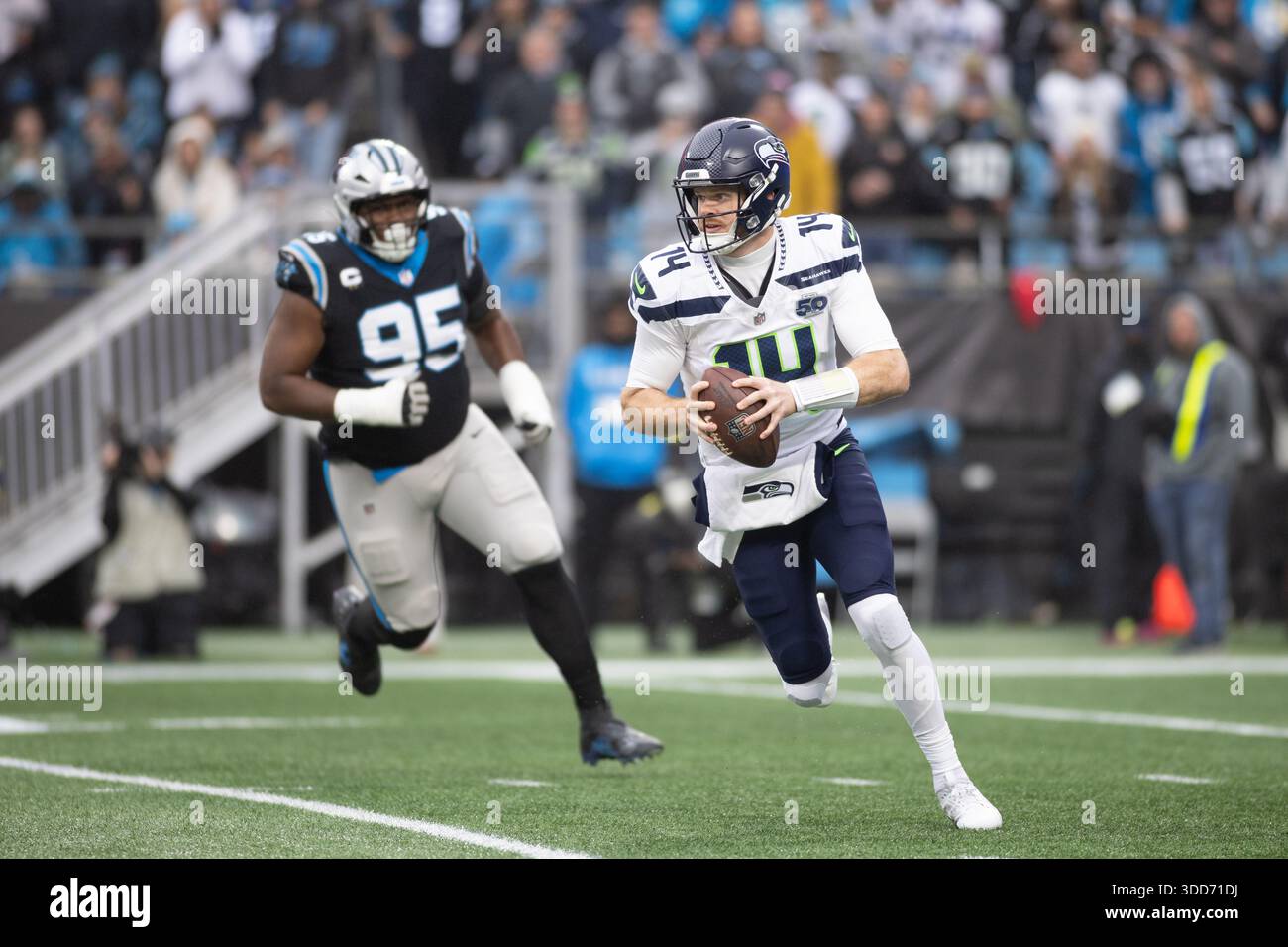 Seattle Seahawks quarterback Sam Darnold (14) rolls out of the pocket ...