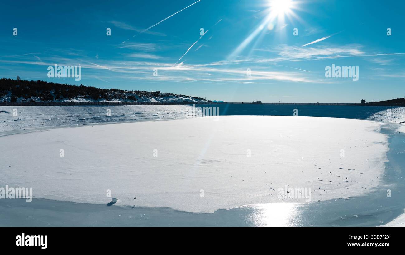 Frozen artificial lake. The sun shines and melts the layer of ice ...