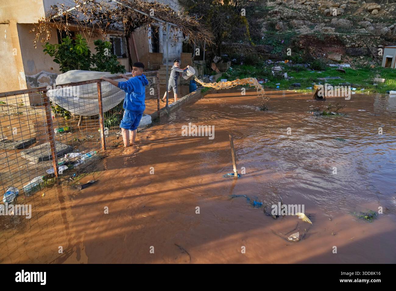 Palestinian youths clear their rain flooded houses during a powerful ...
