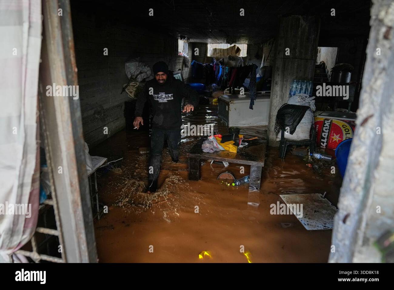 A Palestinian resident inspects his rain flooded house, during a ...