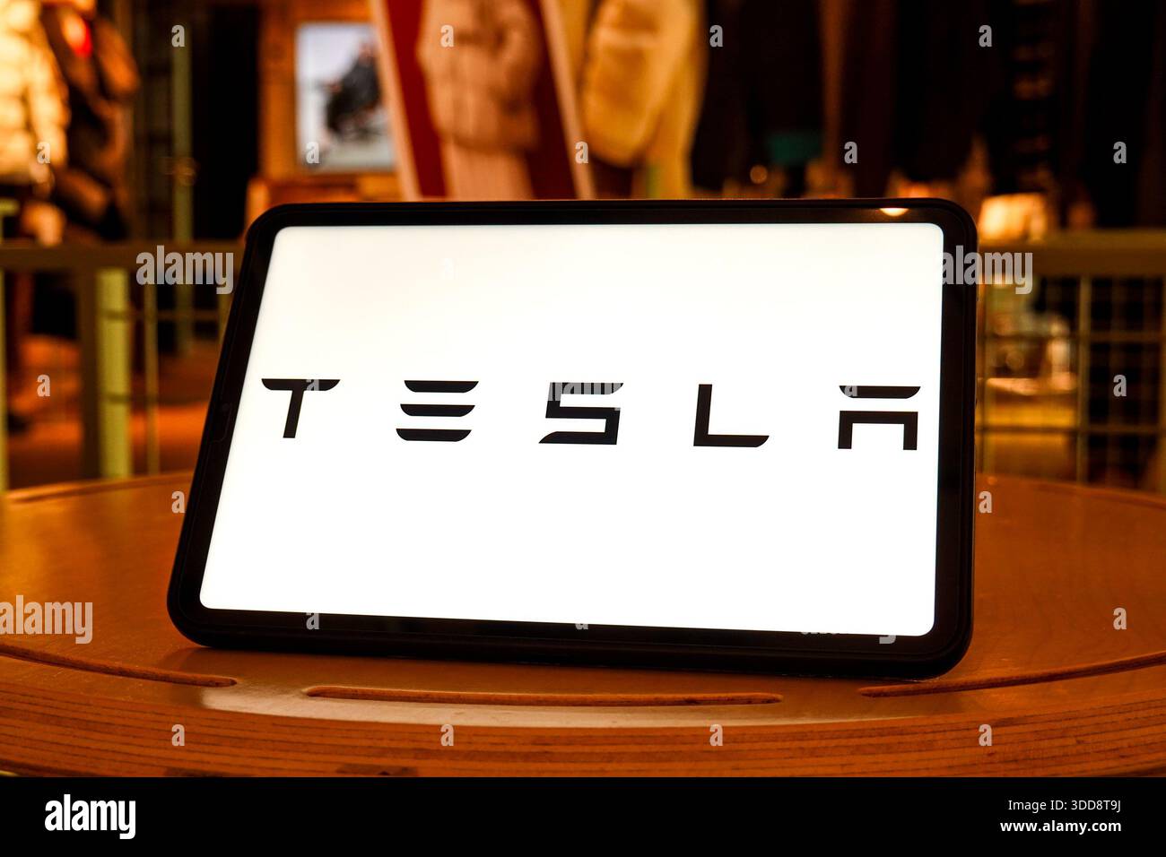 In this photo illustration, the logo of Tesla is seen displayed on the ...