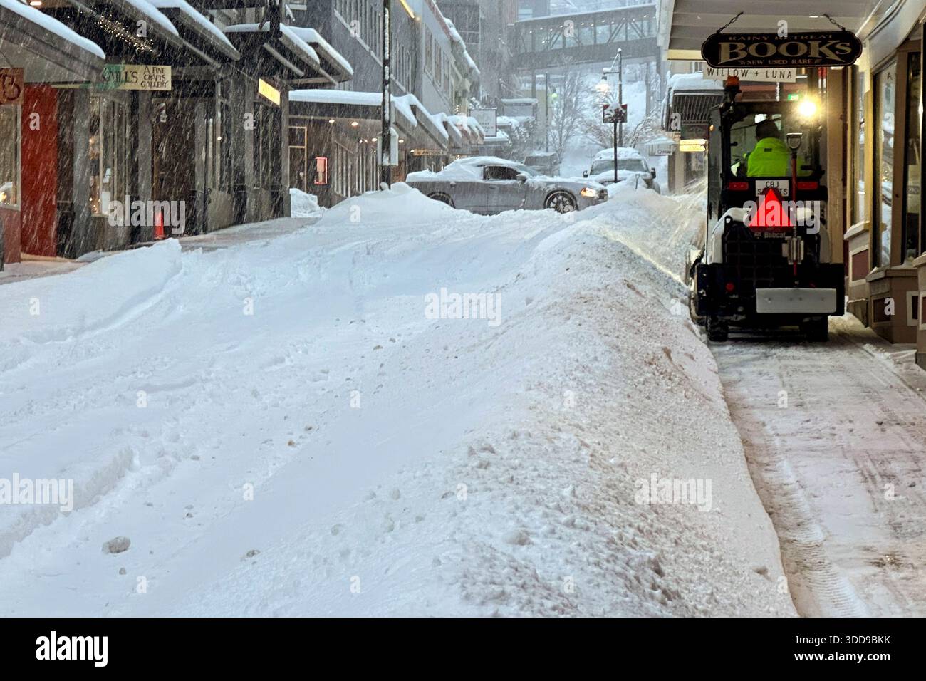 A man clears snow from the sidewalk in downtown Juneau, Alaska, Monday ...