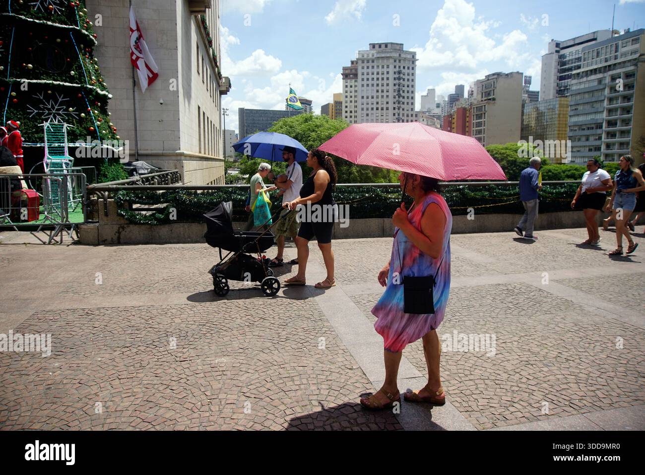 Pedestrians protect themselves from the heat in the central region of ...