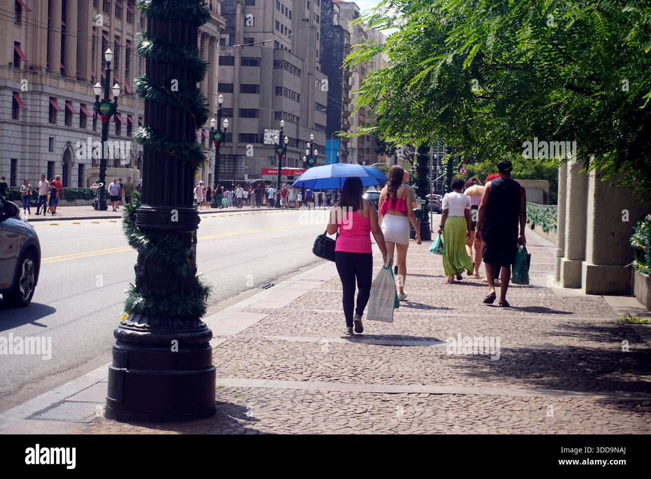 Pedestrians protect themselves from the heat in the central region of ...