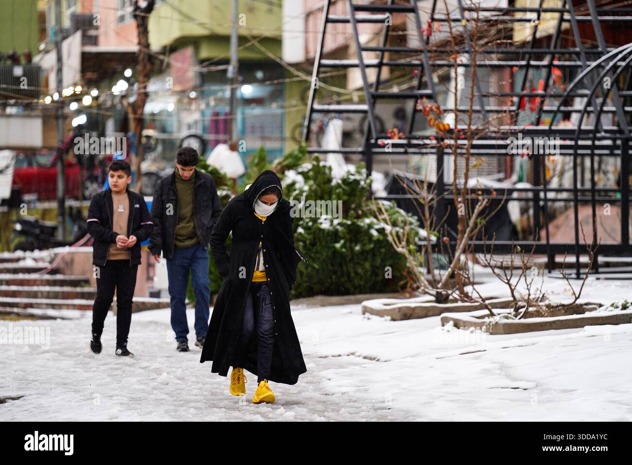 An Iraqi Kurdish woman walks along a street as snow covers in the city ...