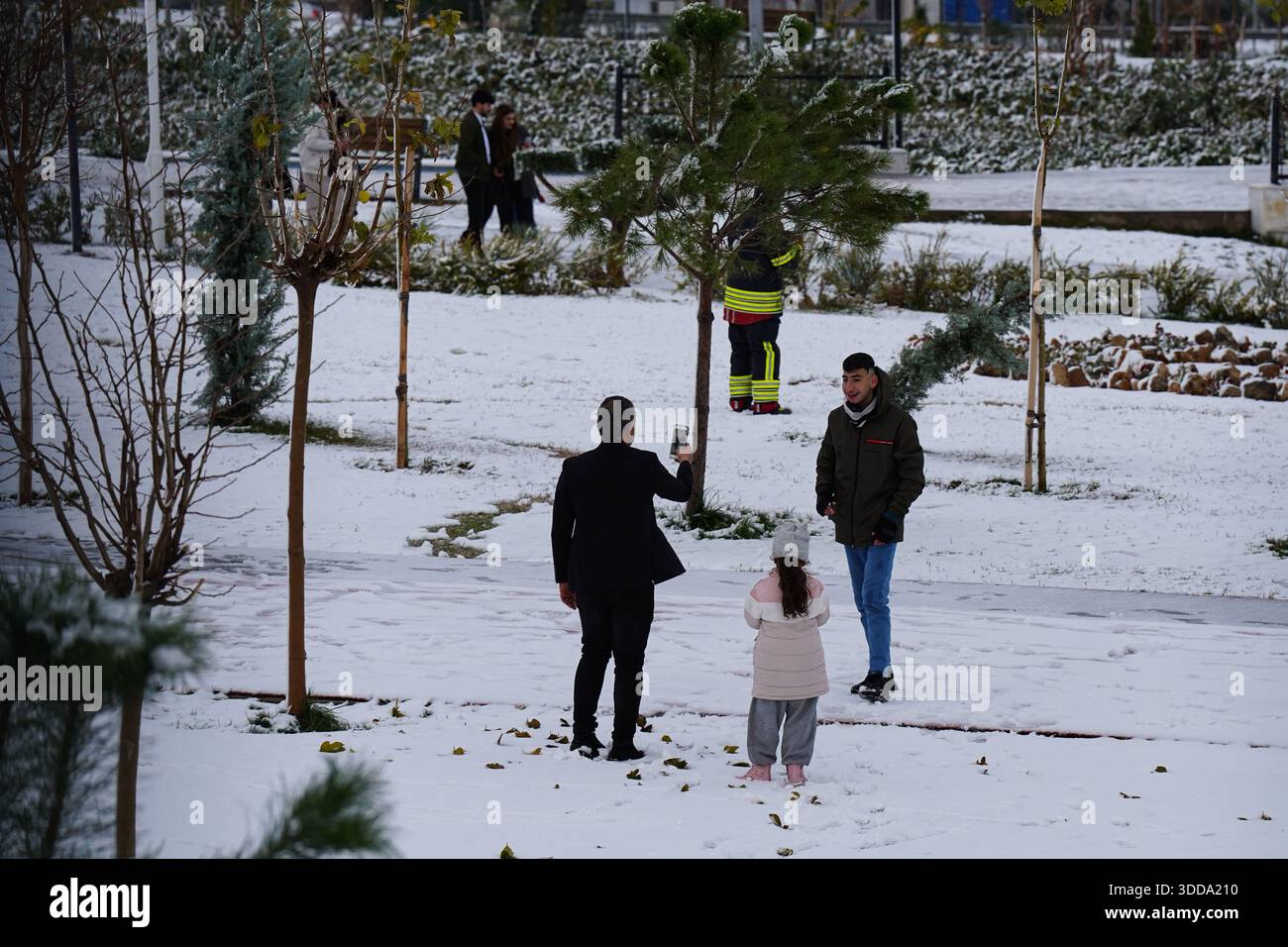 Iraqi Kurdish people take photos at a park as snow covers in the city ...