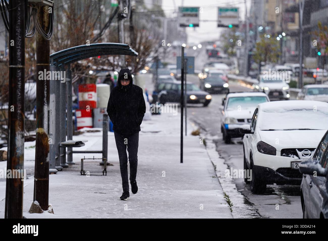 An Iraqi Kurdish man walks along a street as snow covers in the city of ...