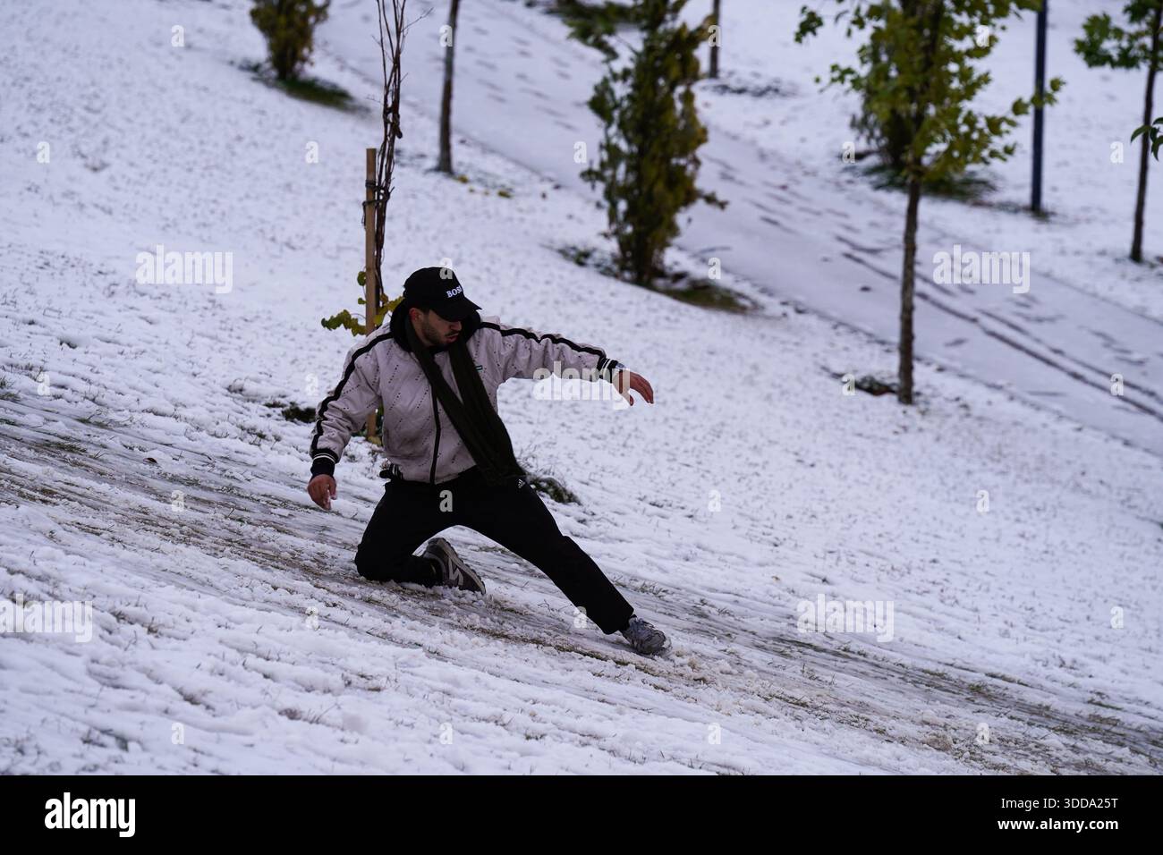 An Iraqi Kurdish young man slides on snow in a park as snow covers in ...