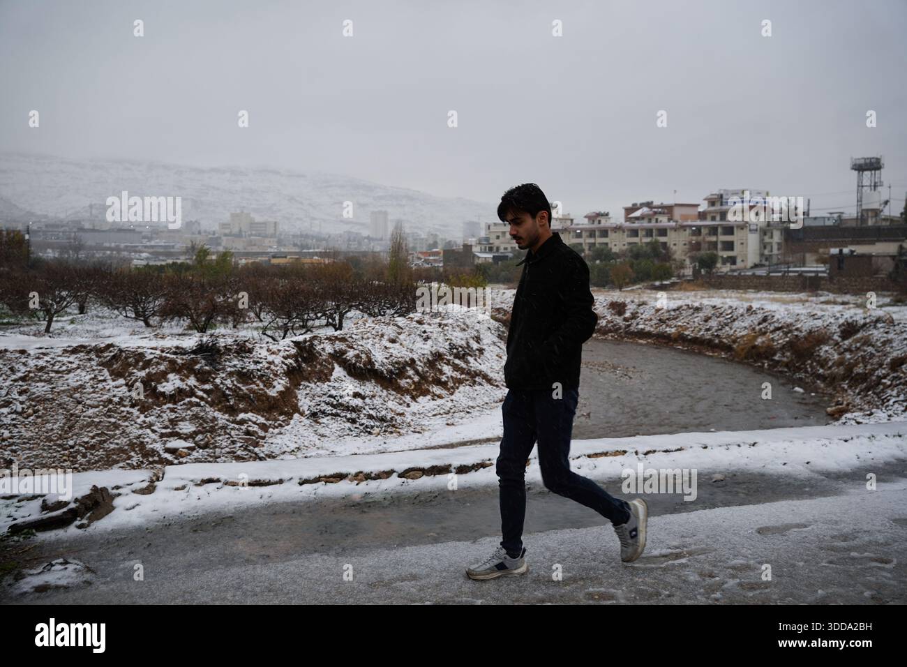 An Iraqi Kurdish man walks along a street as snow covers in the city of ...