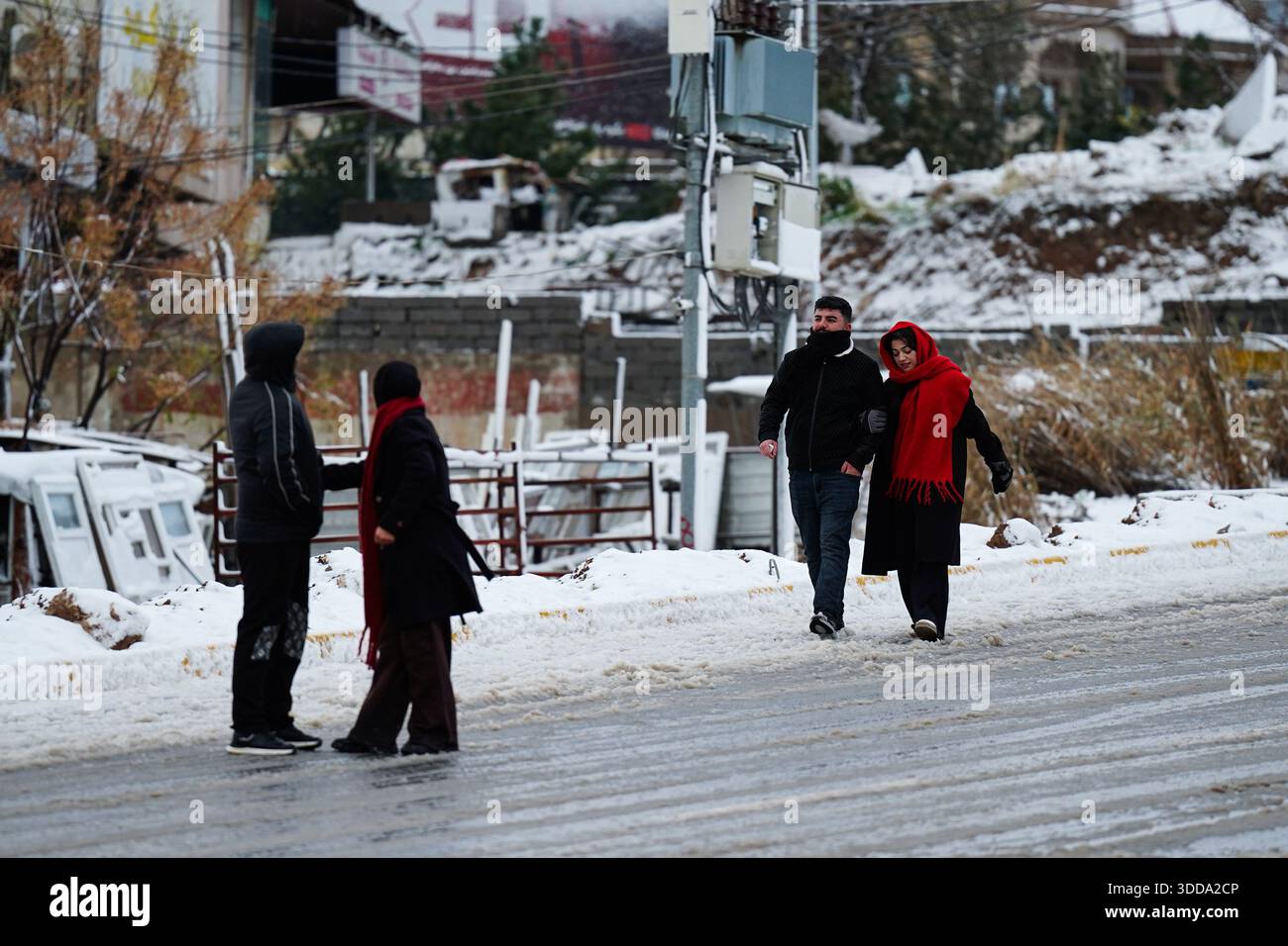 Iraqi Kurdish people walk along a street as snow covers in the city of ...
