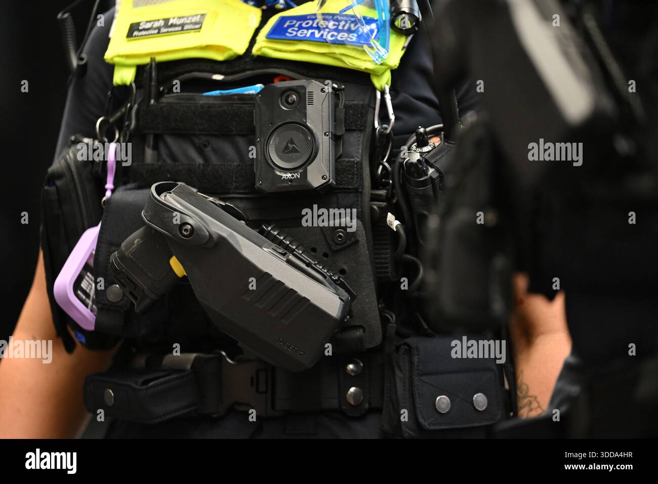Detail image of a taser on the vest of a Victoria Police Protective ...