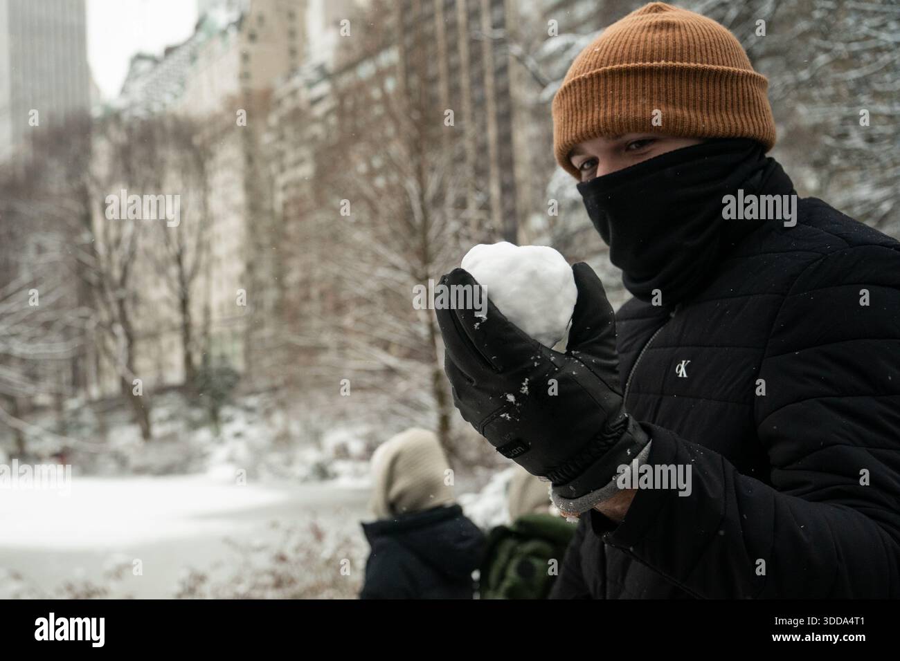 A man holds up his snowball before engaging in a snowball fight with ...