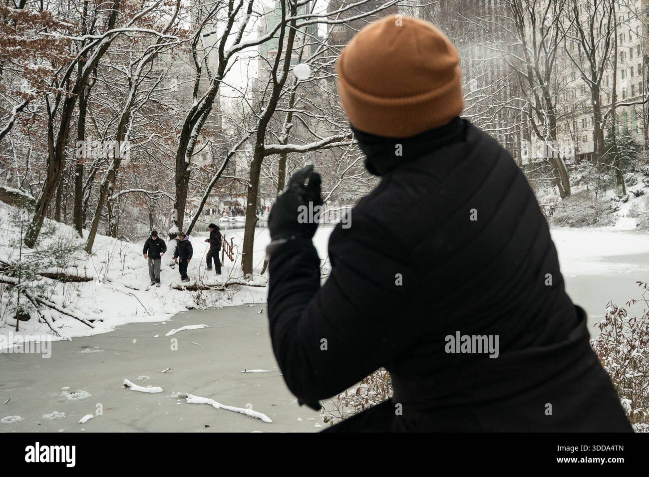 A man engages in a snowball fight with three people across The Pond in ...