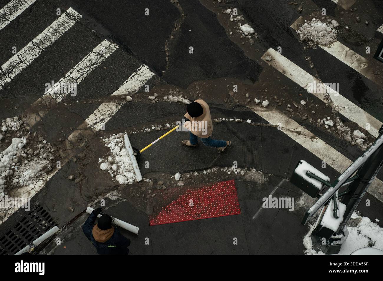 Workers at Hudson Yards clear slush from the roadway after an overnight ...