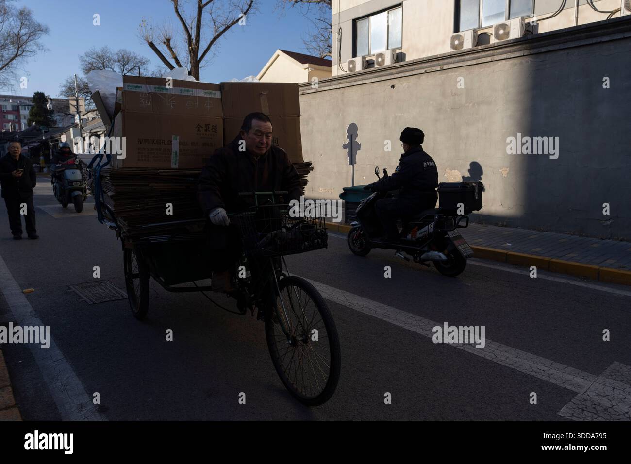 A man transports cardboard boxes in Beijing, Wednesday, Dec. 24, 2025 ...