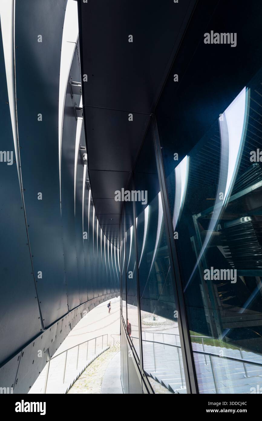 Tooth-shaped lights from curved aluminium slats on the modern glass ...
