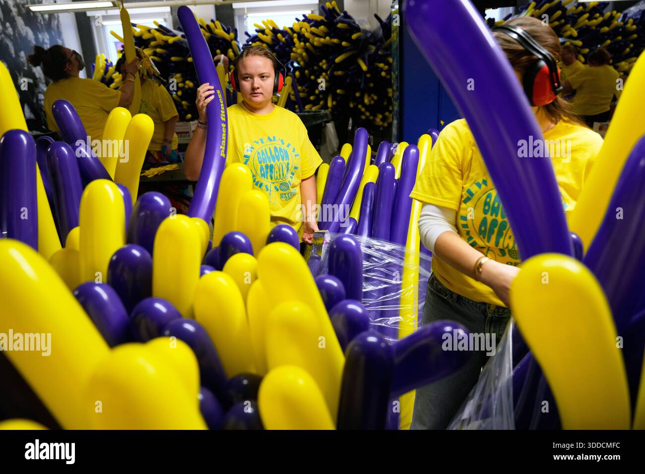 Quinn Milner helps to inflate and organize some of 25,000 balloons ...