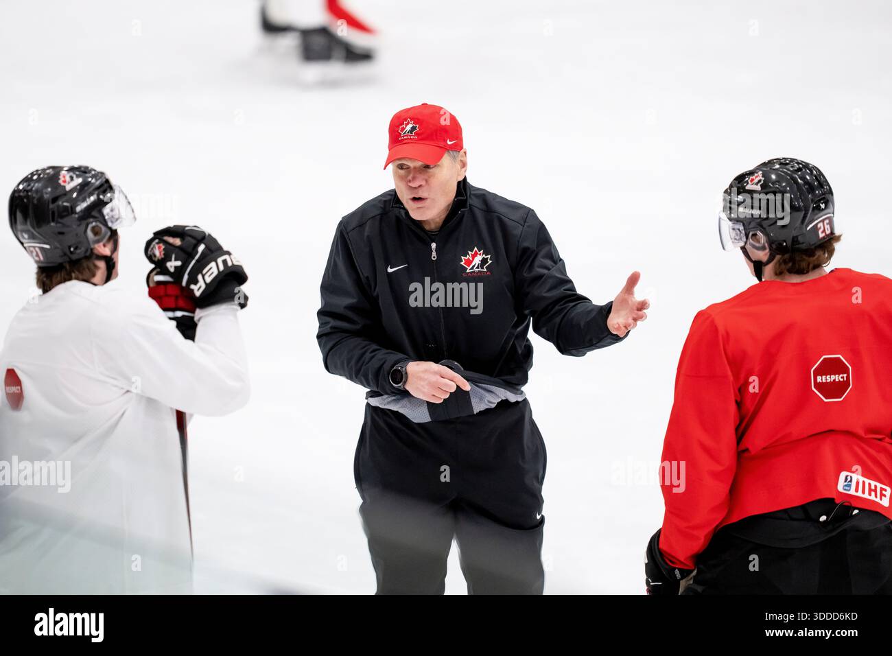 Team Canada assistant coach Brad Lauer speaks to Canada's Cole Reschny ...