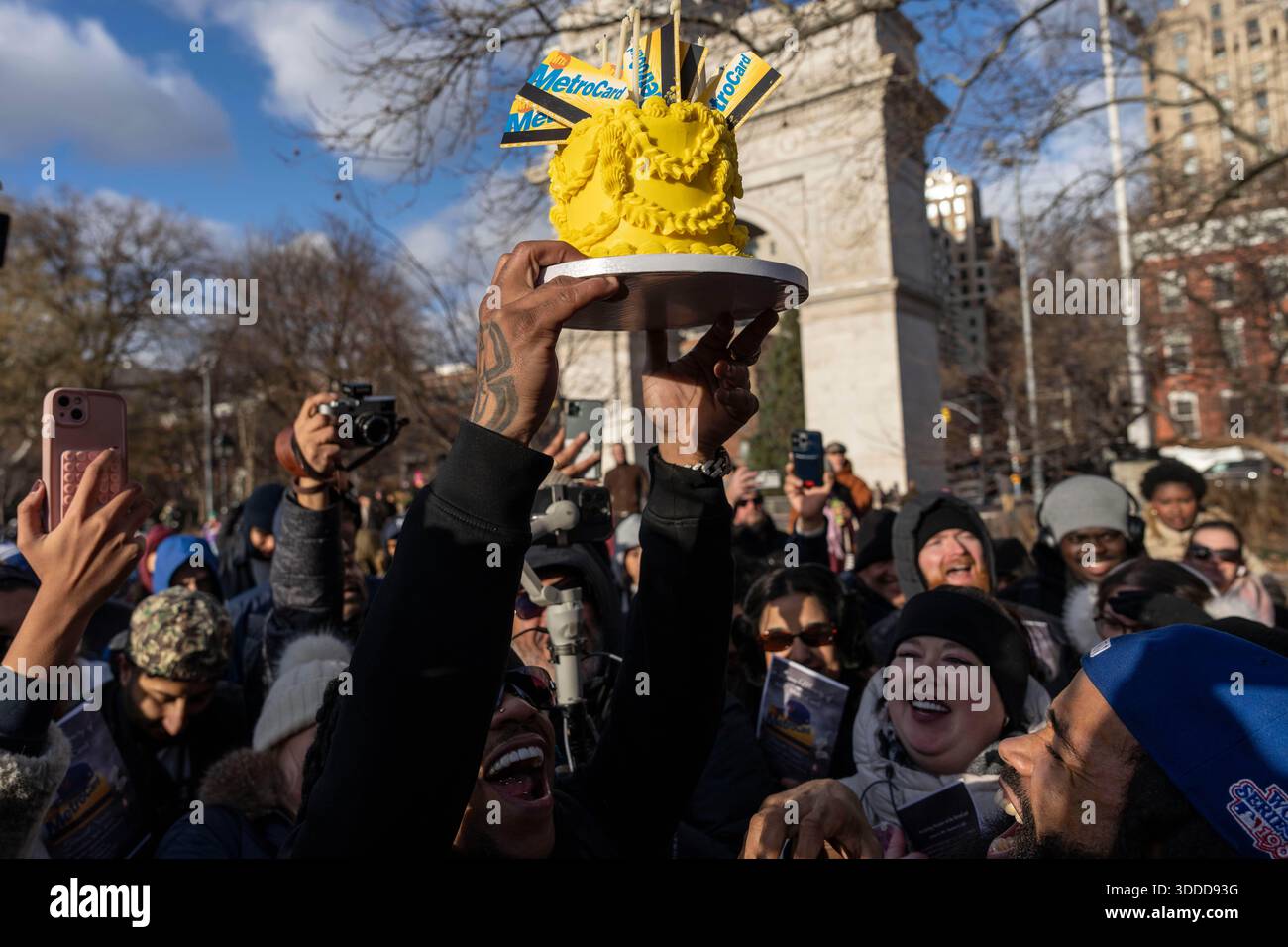 A person raises a Metrocard-themed cake during the Metrocard funeral ...