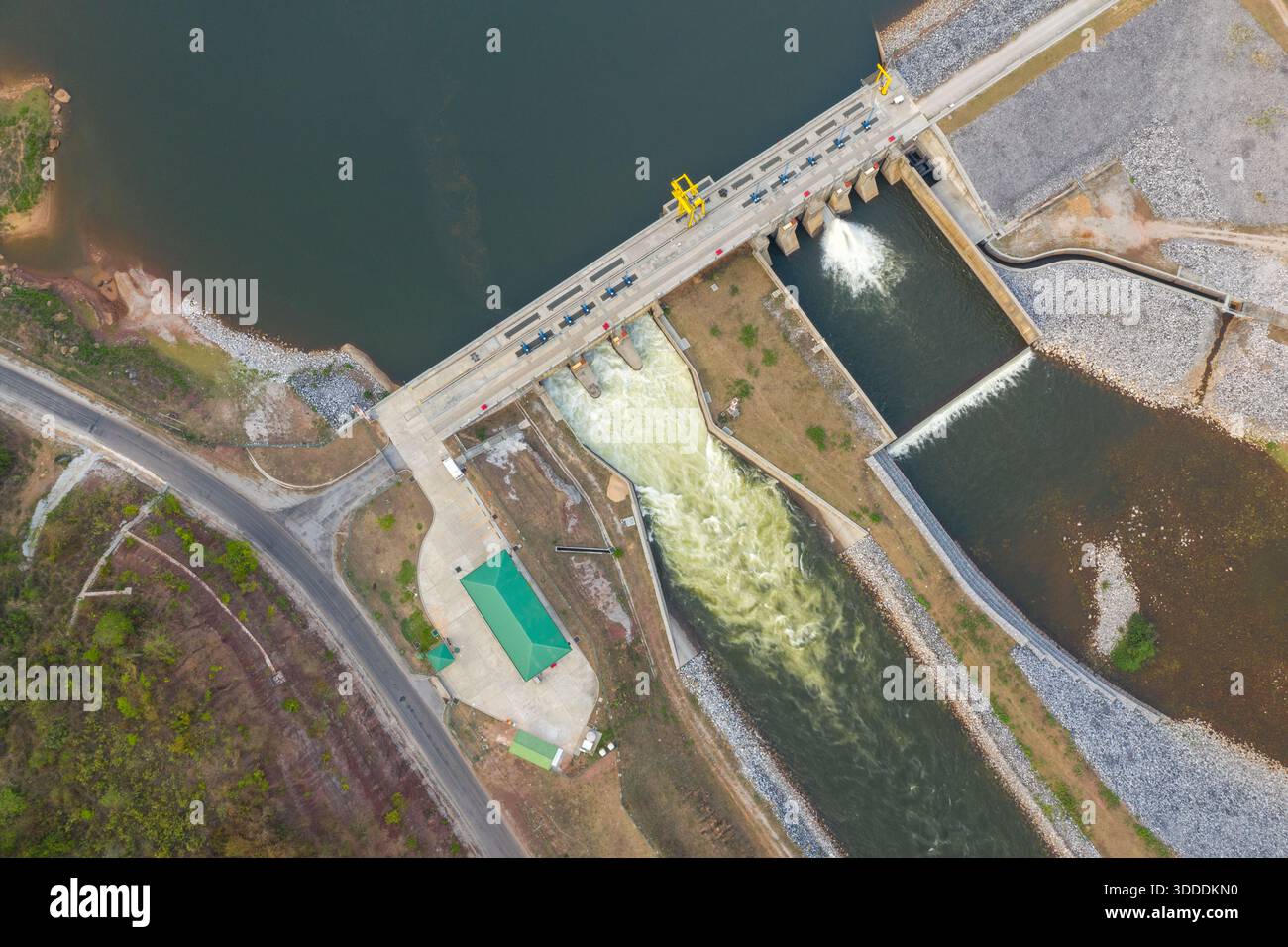 Top-down image displays a modern hydroelectric dam spanning a calm ...