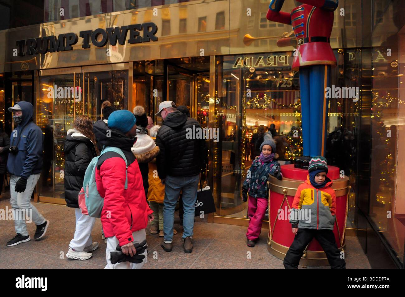 People take photos outside of Trump Tower, which is decorated in ...