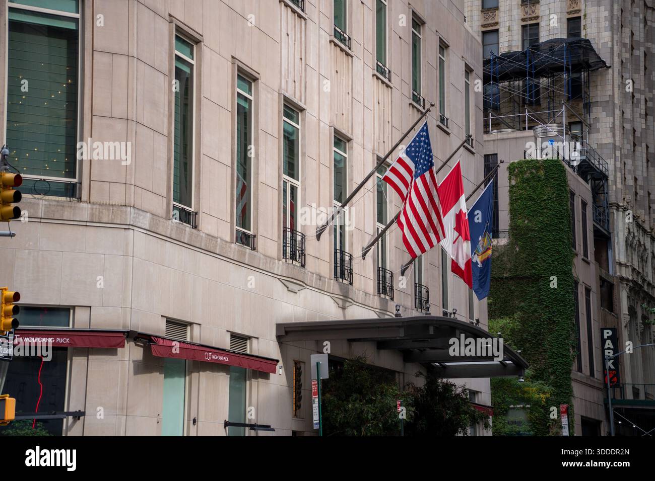 Three national and state flags wave proudly from a modern building's ...