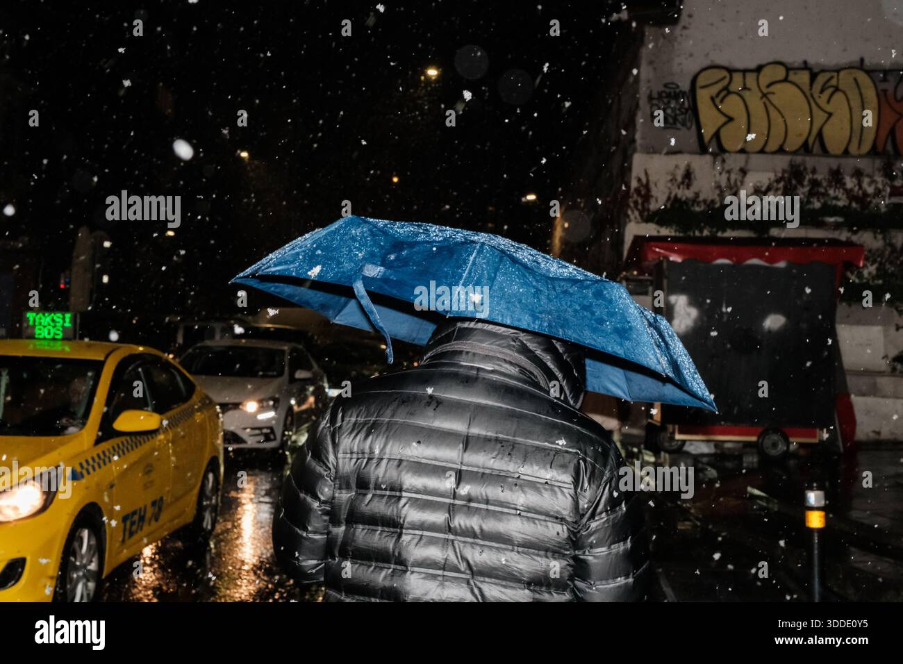 People are walking under the snow with their umbrellas. Snowfall has ...