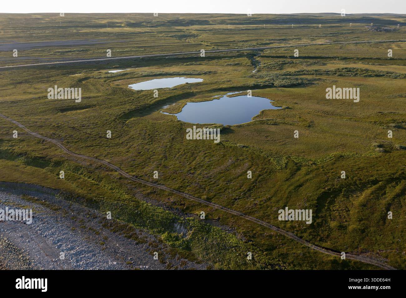 Coastal landscape on Varanger Fjord with blue sky, still sea, moors and ...