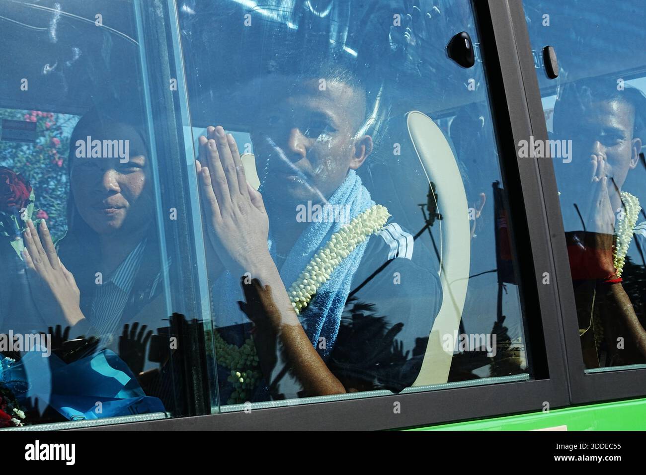 Cambodian soldiers greet villagers from a bus upon arrival at a former ...
