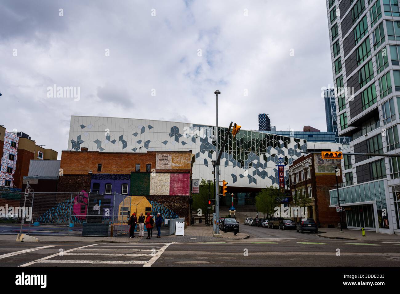 Street art covers a brick building beside the modern facade of Calgary ...
