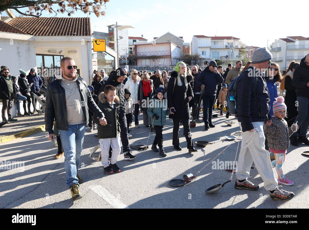 People walk and drag their pots through the streets of Primosten, small ...