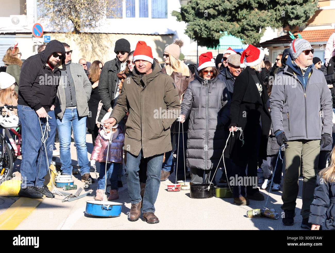 People walk and drag their pots through the streets of Primosten, small ...