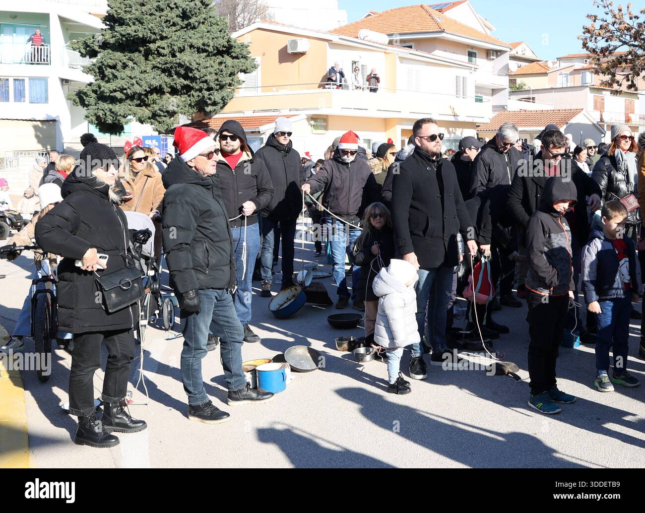 People walk and drag their pots through the streets of Primosten, small ...