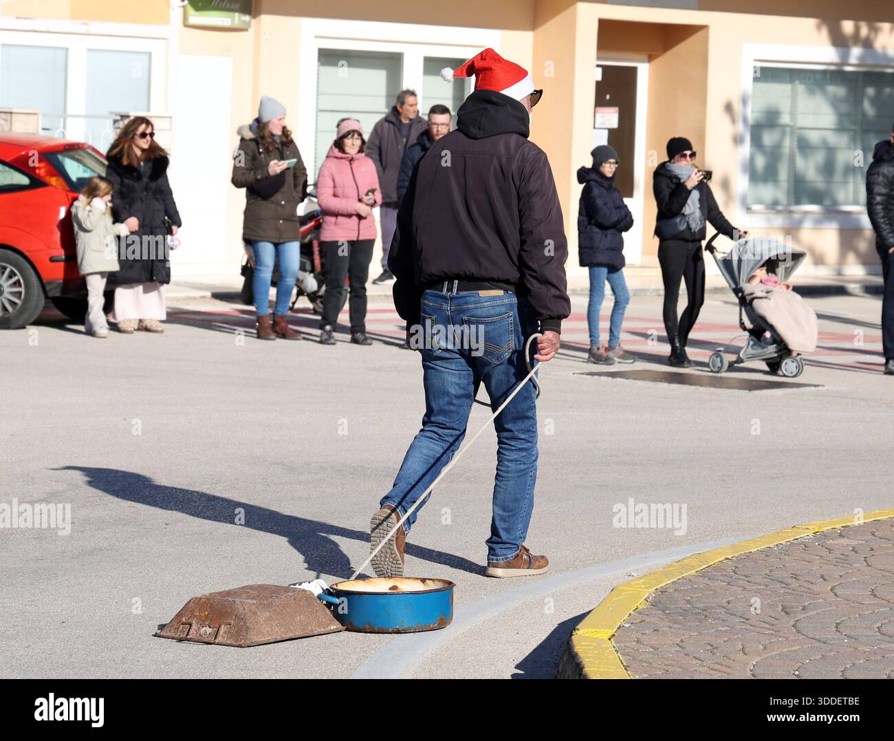 People walk and drag their pots through the streets of Primosten, small ...
