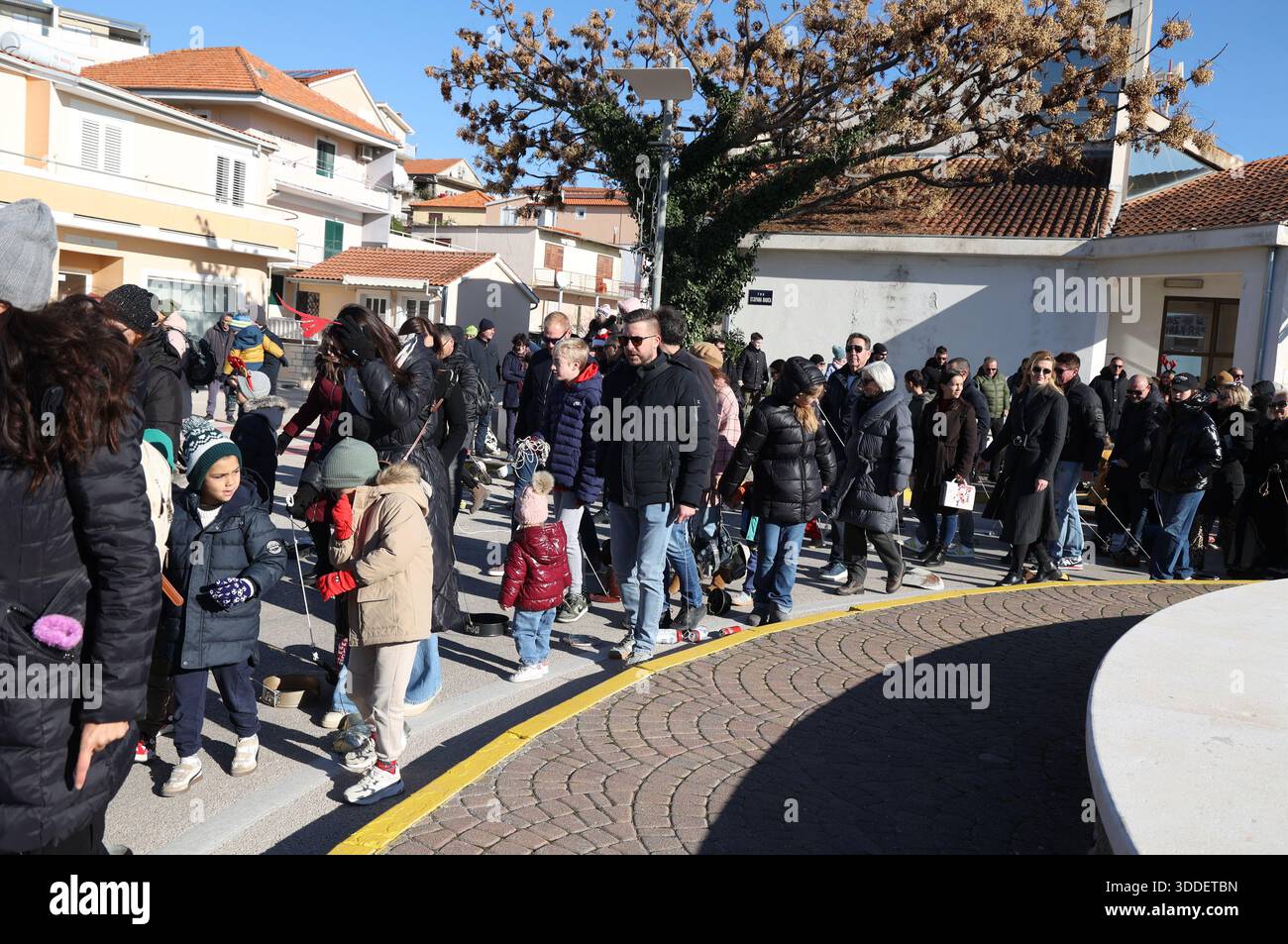 People walk and drag their pots through the streets of Primosten, small ...