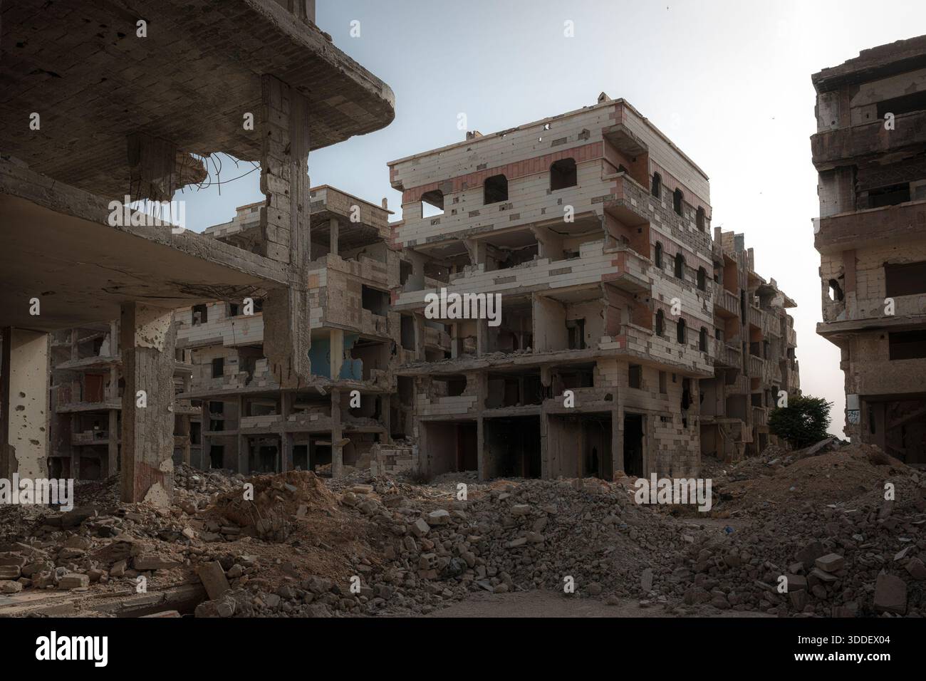 Damaged residential towers surround piles of rubble in varying stages ...