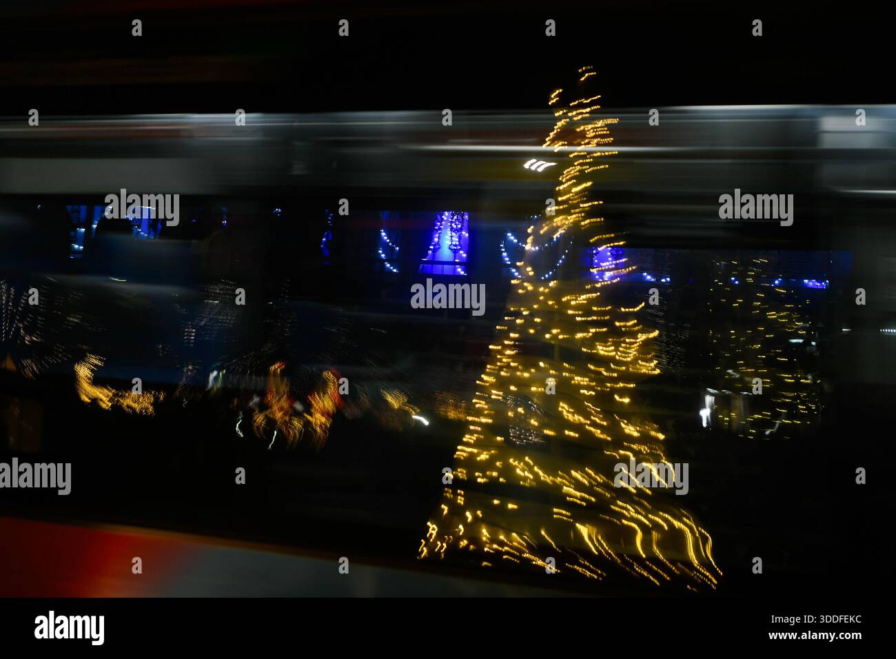 Reflection of a decorated christmas tree in a moving bus outside The ...